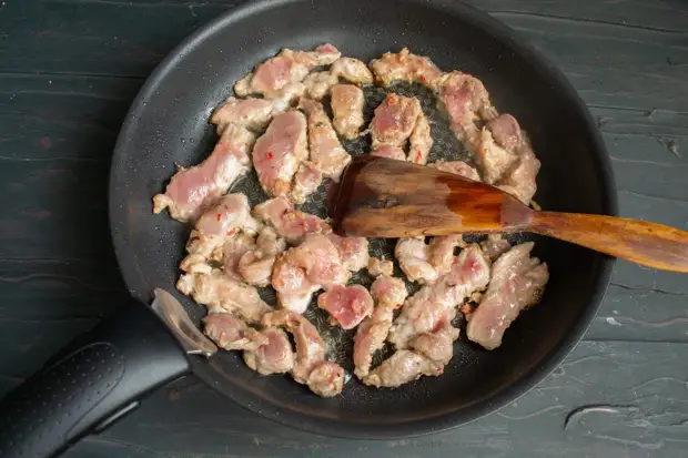 Maiale piccante con mele in una padella